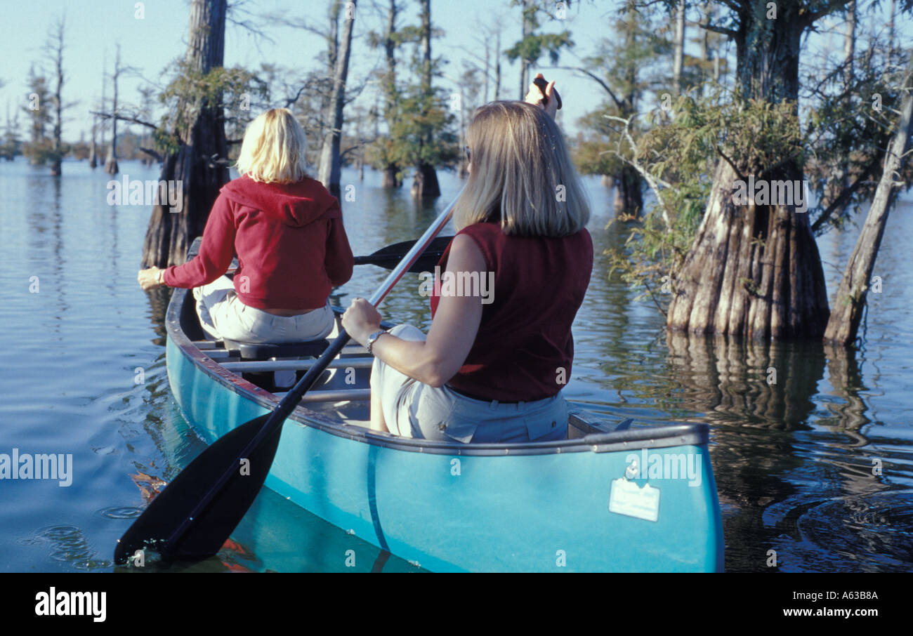 Two beautiful young blonde women in canoe on Black Bayou Lake near ...
