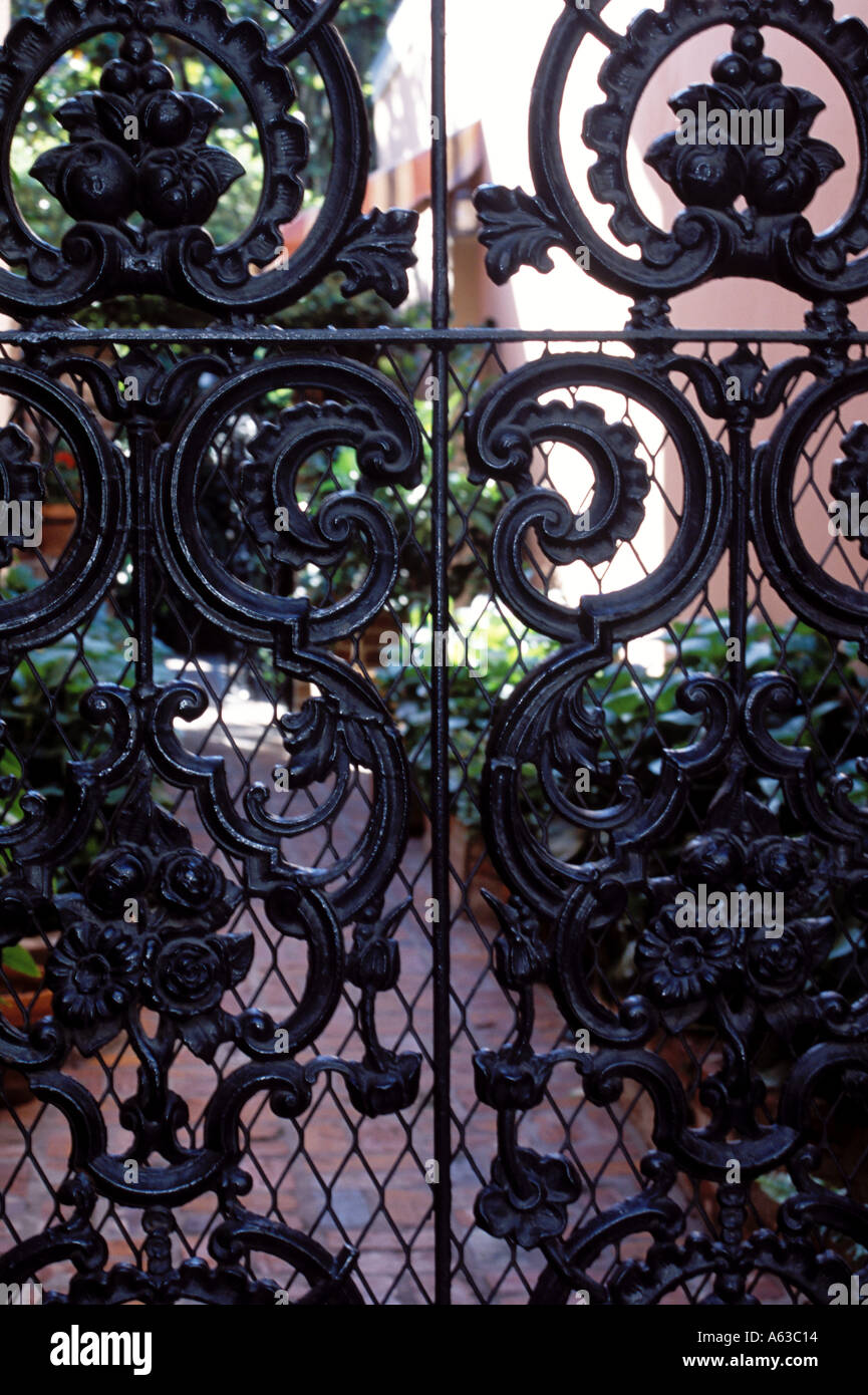 Decorative ironwork gate in front of intimate garden New Orleans ...