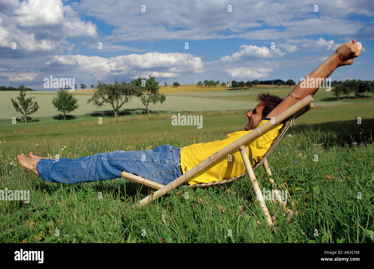 Man sitting in deck chair side view Stock Photo - Alamy