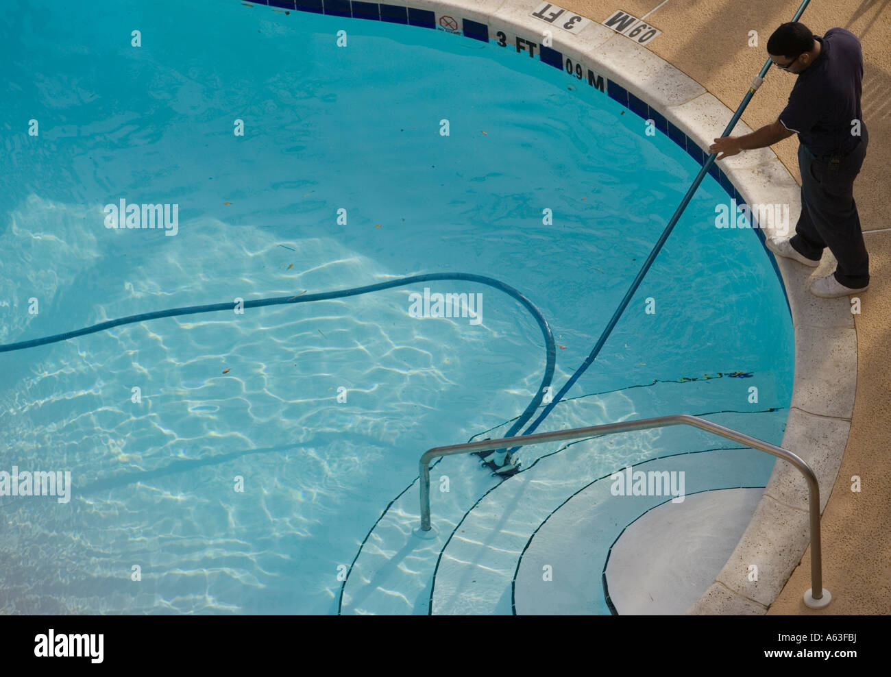 Worker cleaning a swimming pool Stock Photo - Alamy