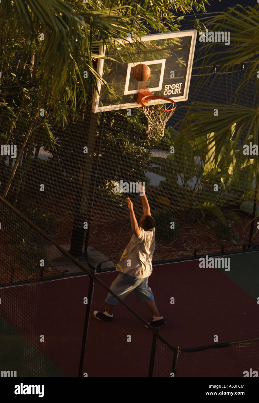 Young man shooting a basketball on an outdoor court Stock Photo - Alamy