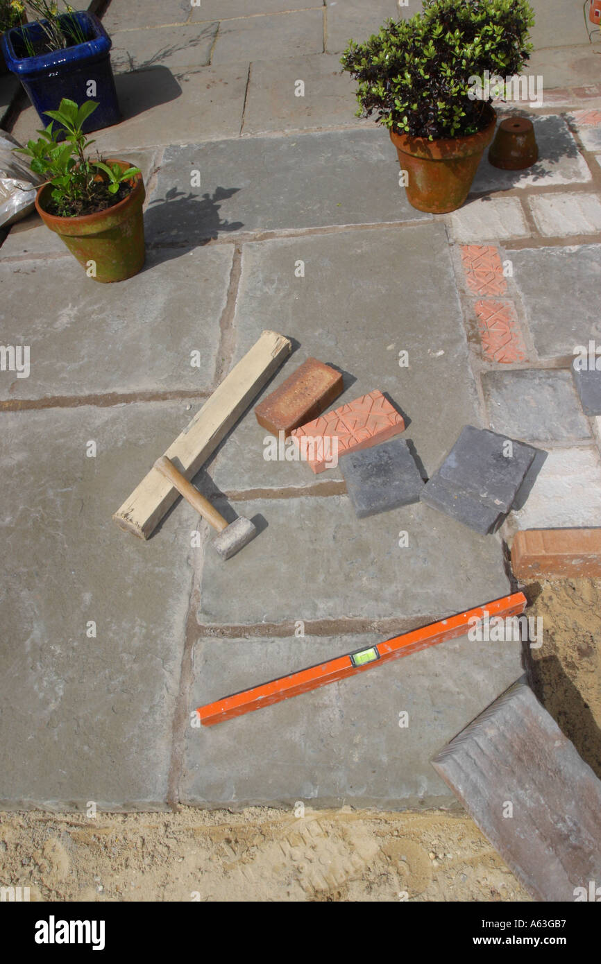 Building a garden patio tools and slabs Stock Photo - Alamy