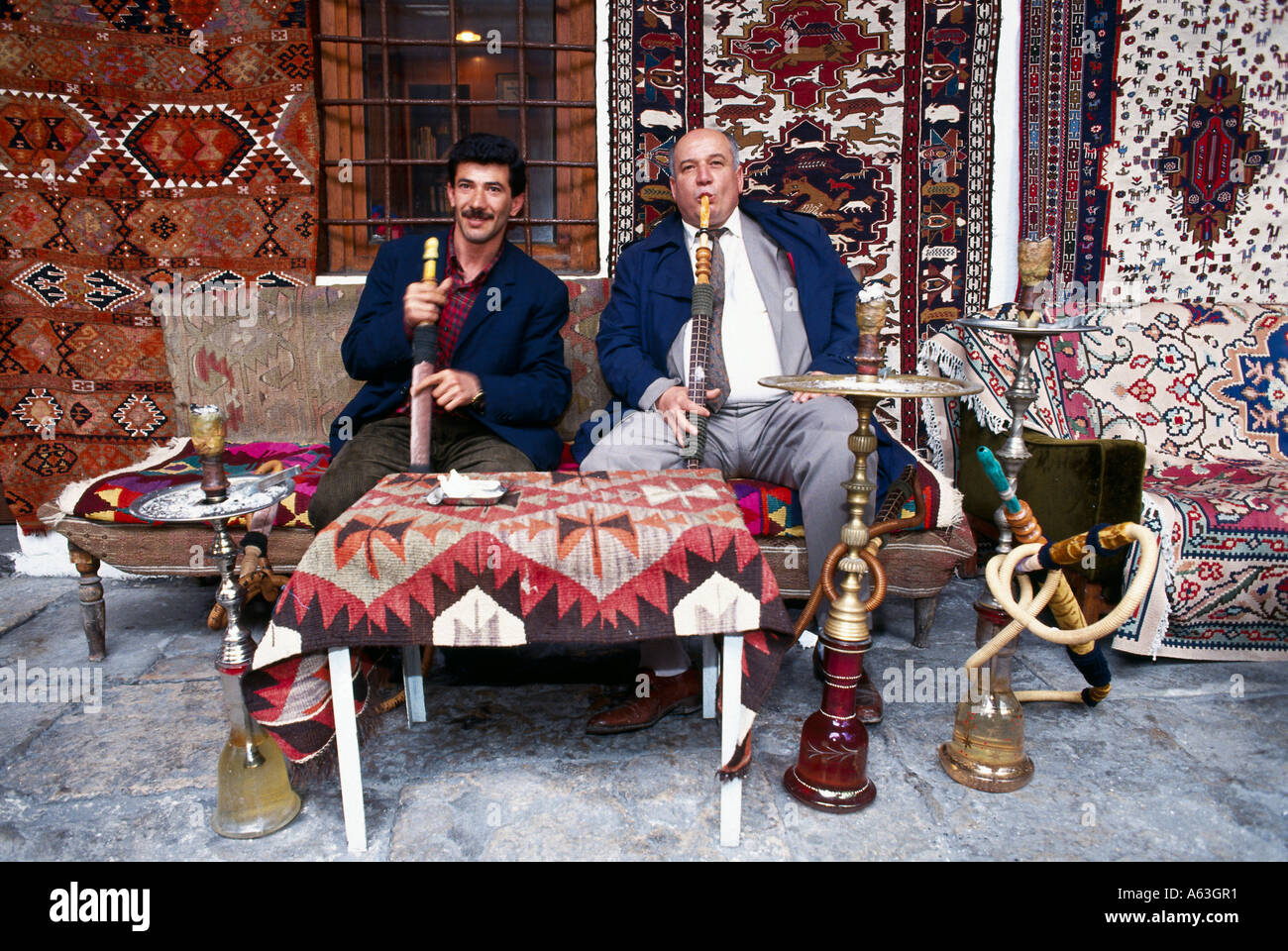 Two men smoking hookah on sofa hi-res stock photography and images - Alamy