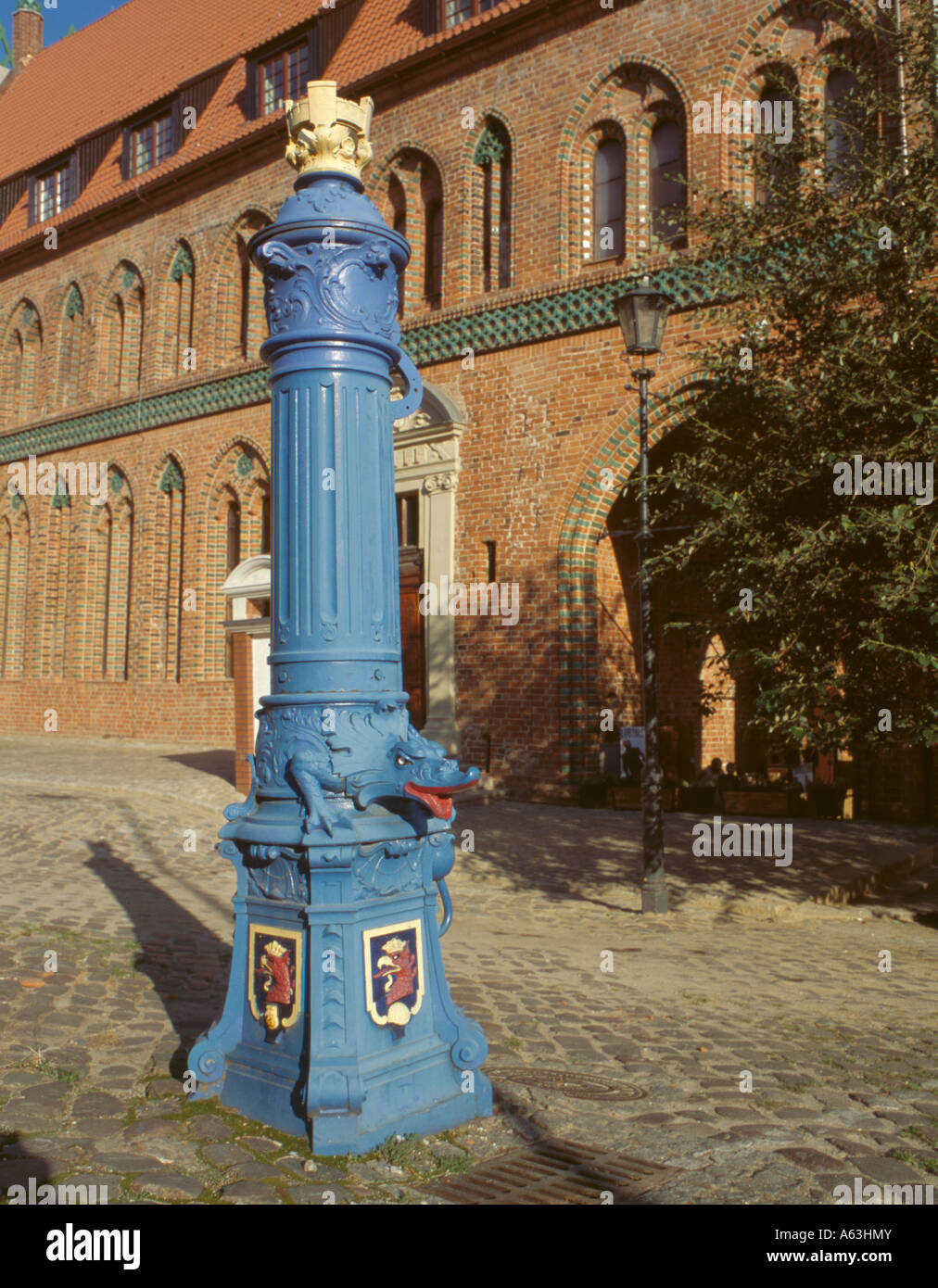 Old cast iron water pump with 15 th century Gothic Ratusz (Town Hall ...