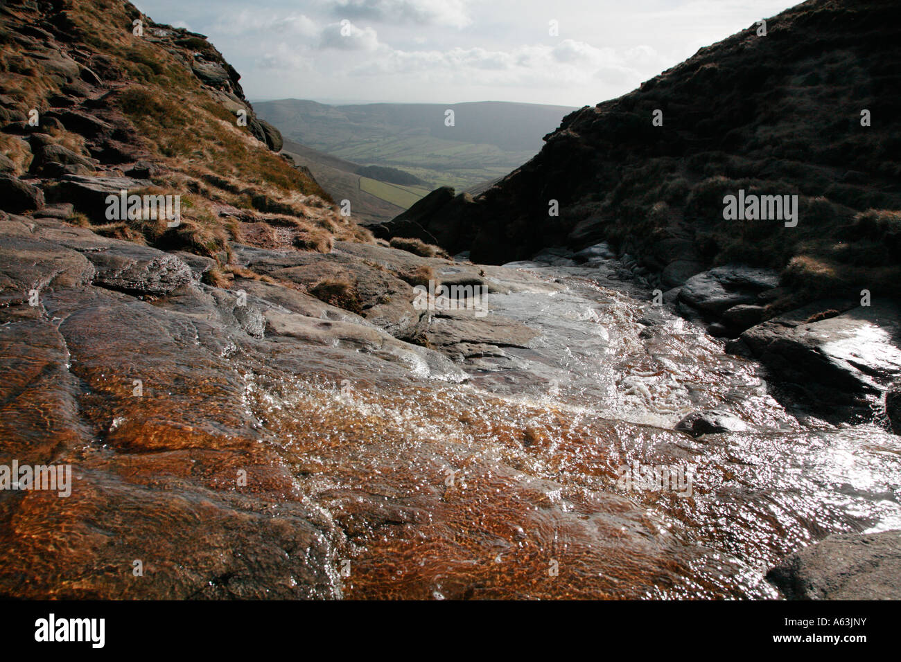 The peaty waters of Crowden Brook rush over the plateau edge of Kinder ...