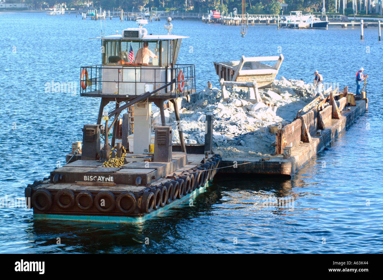 tug boat moving barge loaded with debris at construction site barges ...