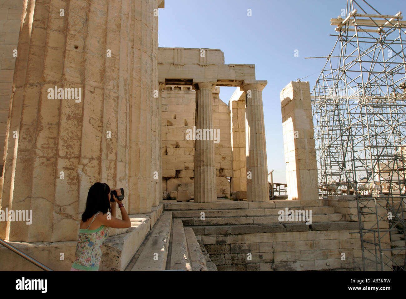 Female tourist photographing restoration works of the doric columns of ...