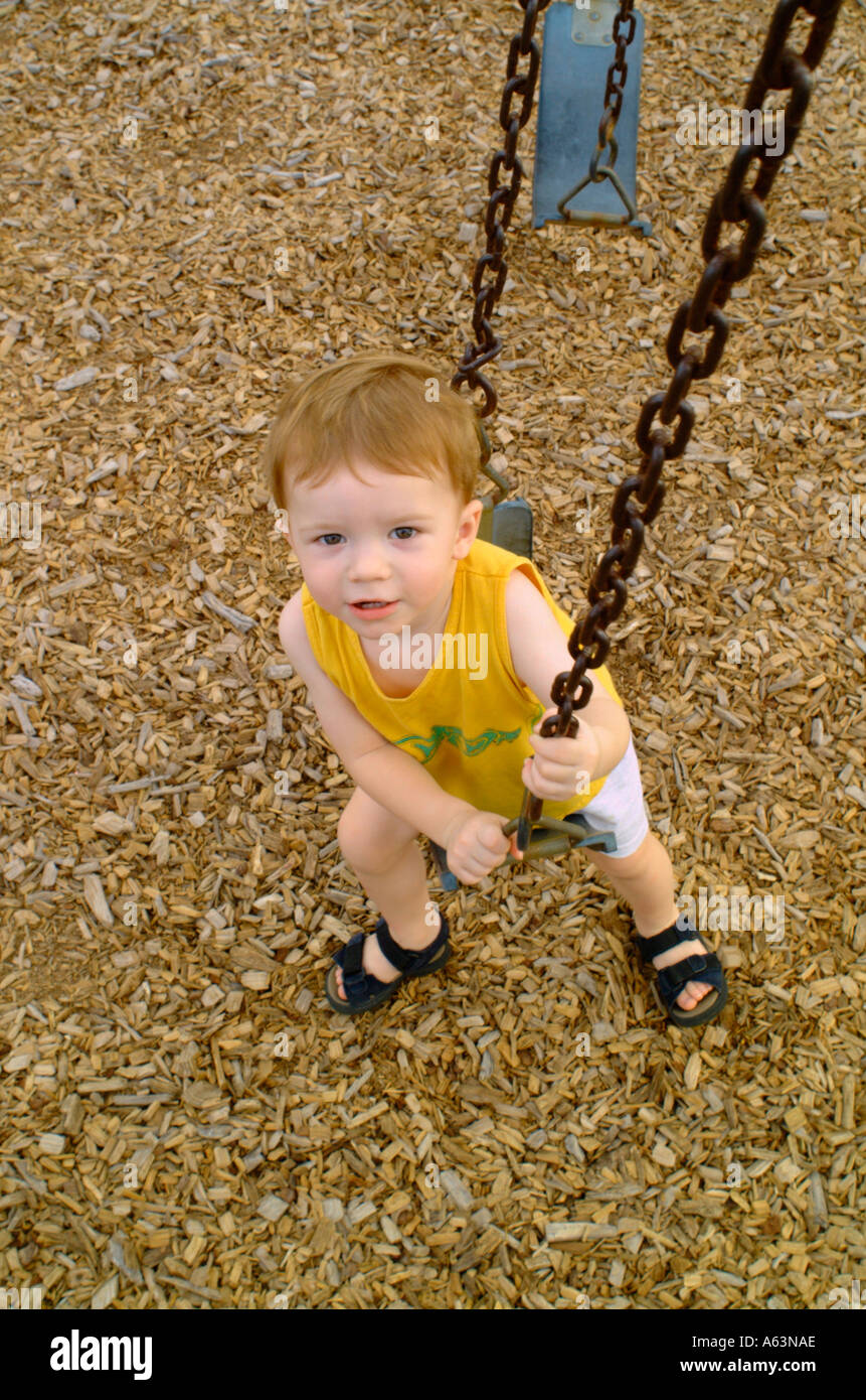 boy playing on swing at public park playground Stock Photo - Alamy