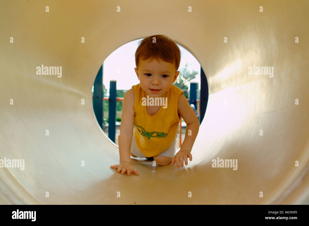 Toddler in playscape tube at public park boys children parks rides ...