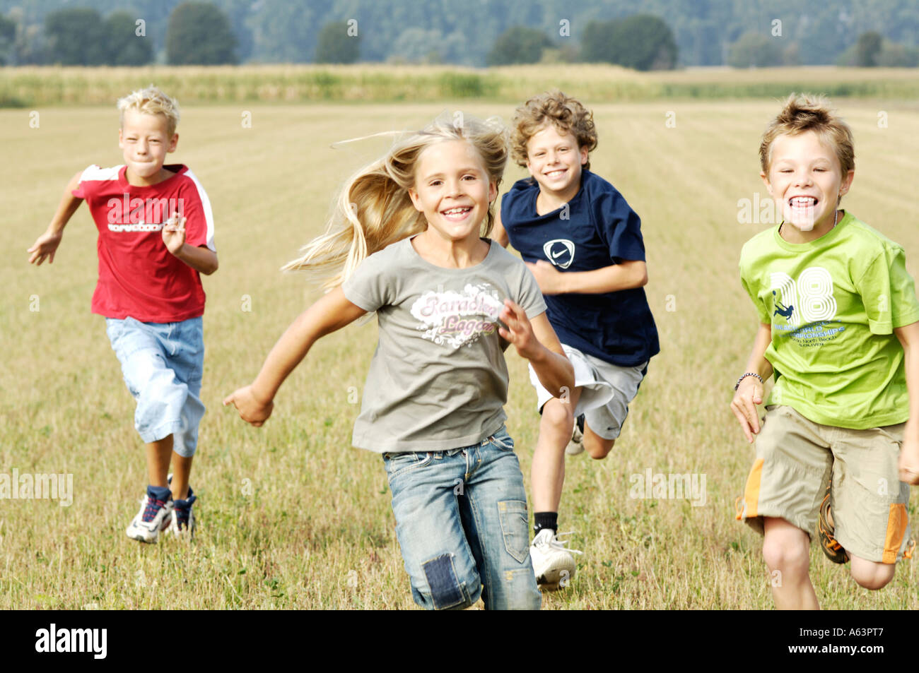Children running over field Stock Photo - Alamy