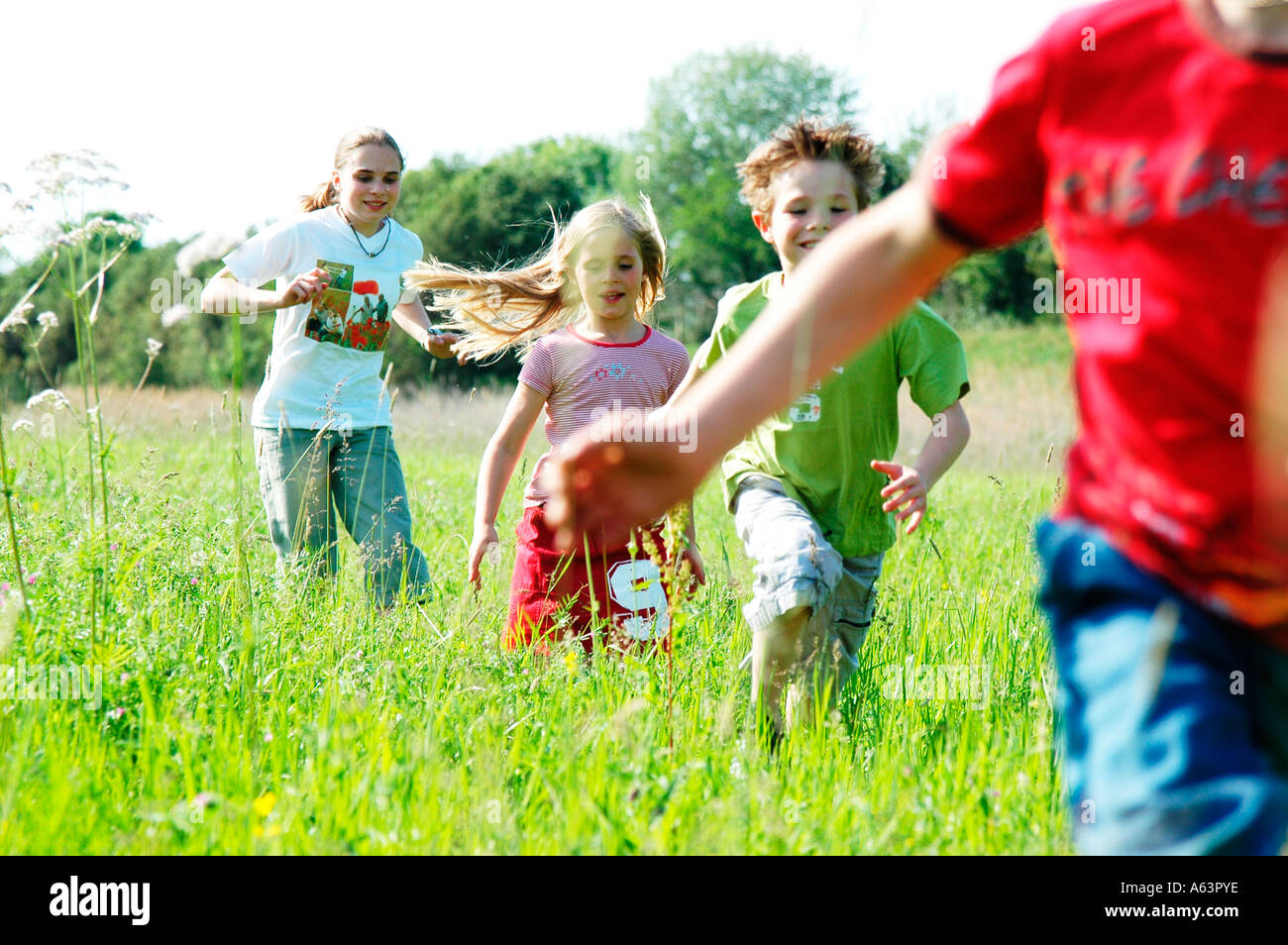 Children running over meadow Stock Photo - Alamy