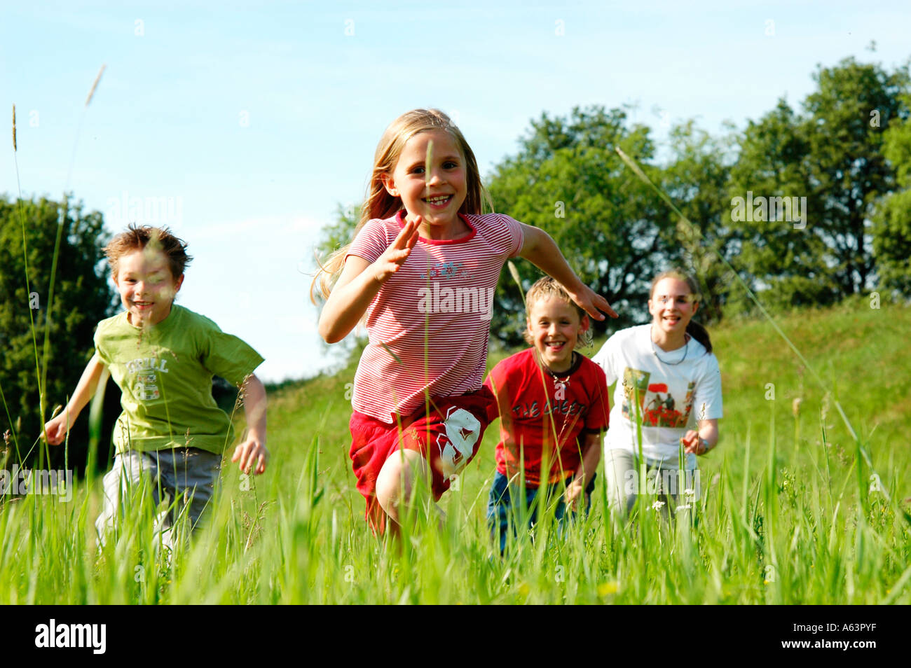 Children running over meadow Stock Photo - Alamy