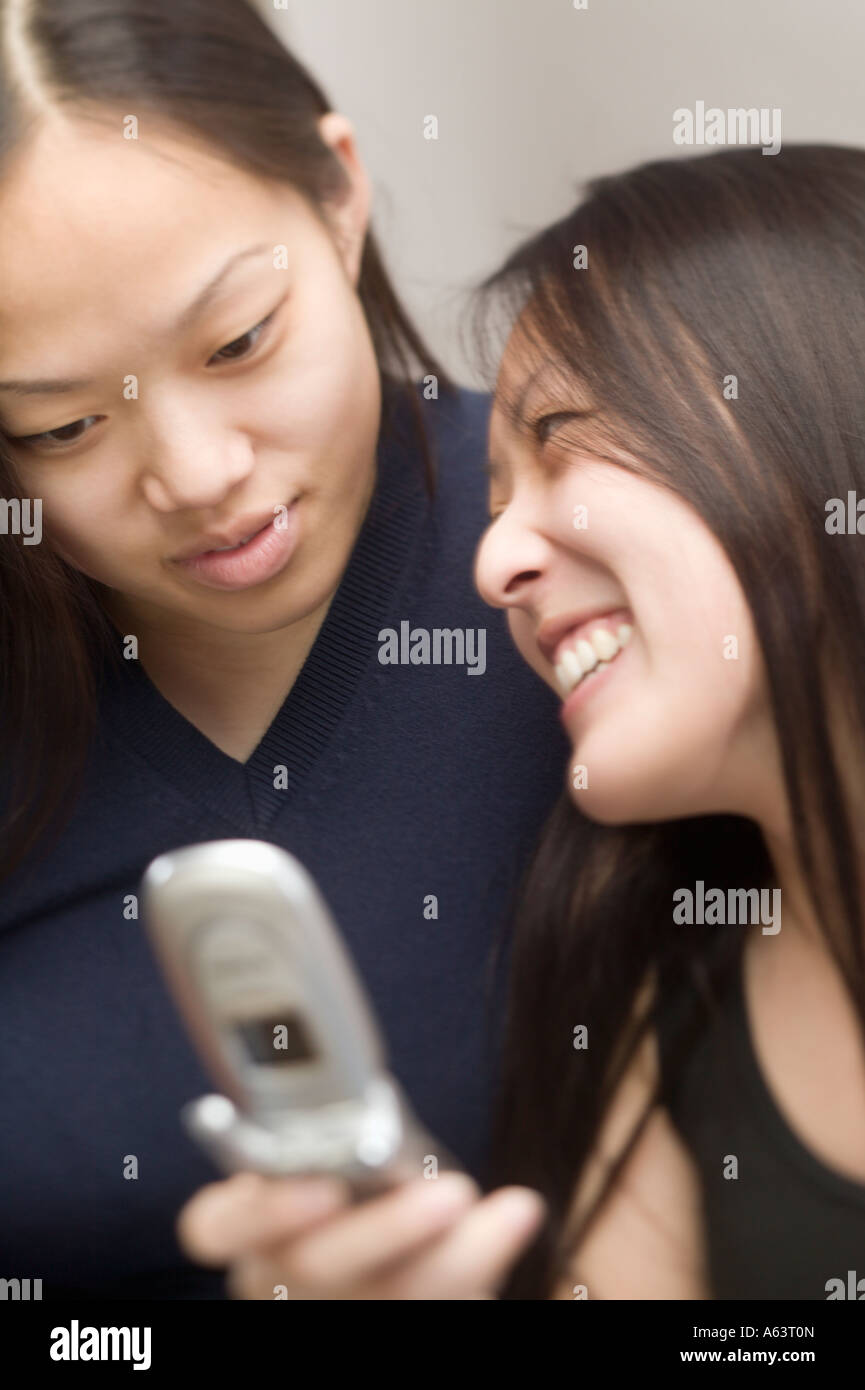 Two Asian women using cell phone Stock Photo - Alamy