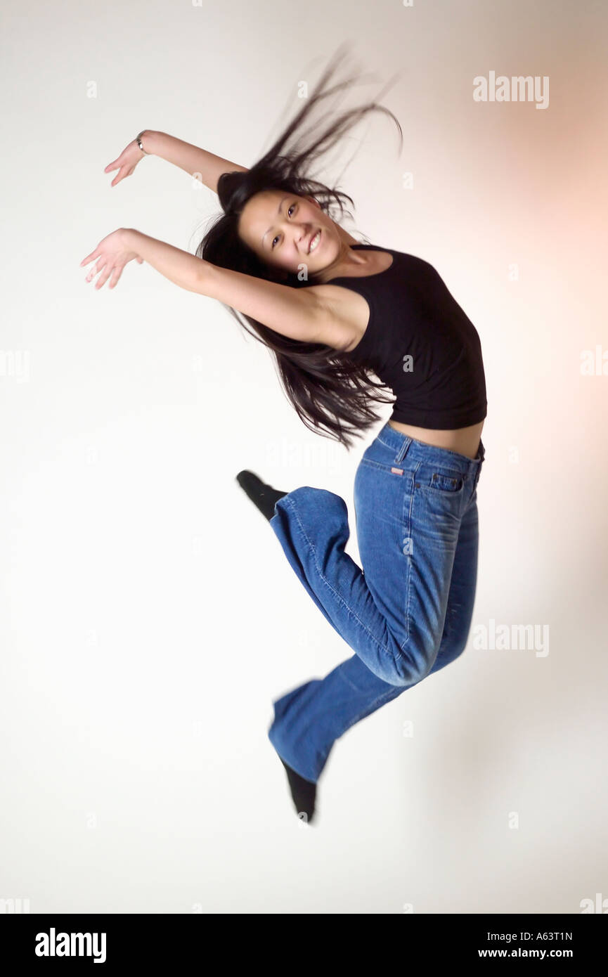 Asian woman leaping for joy Stock Photo - Alamy
