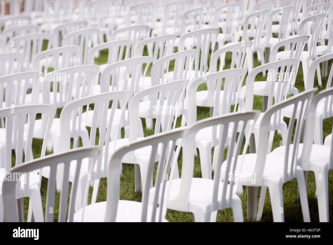 White plastic chairs set for an event Stock Photo - Alamy