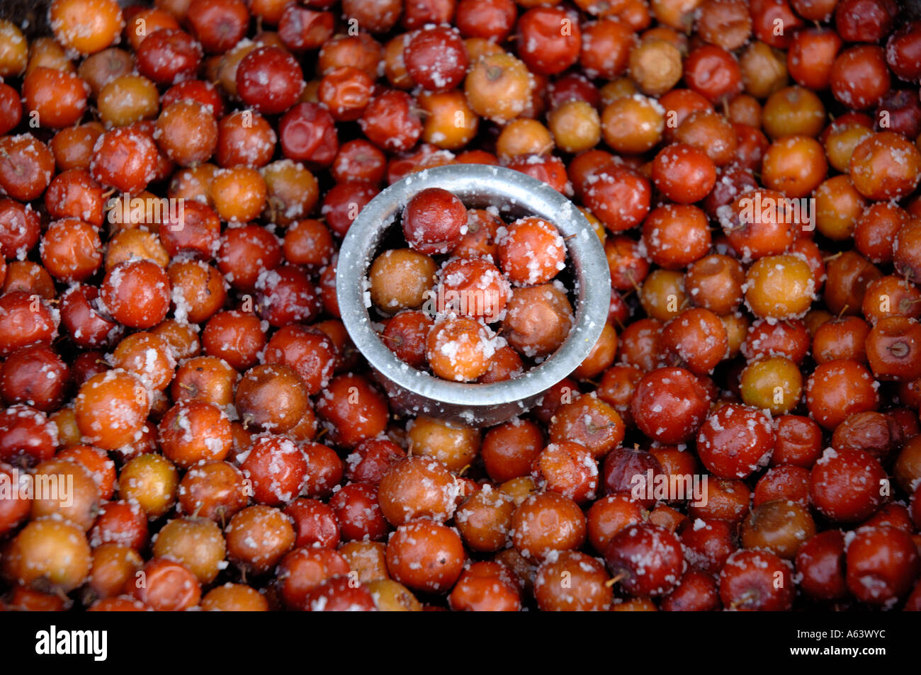 Salted red berries sold on streets by aluminium measure in India Stock ...
