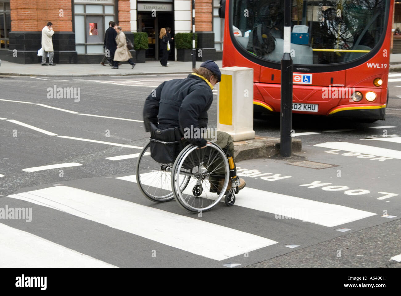 Disabled man in a wheelchair on a zebra crossing, London, England, UK ...