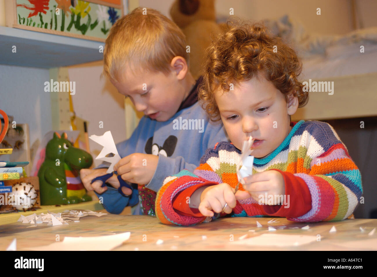 Three year old girl and seven year old boy playing doing handycrafts ...
