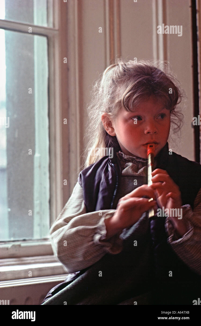 Little girl playing flute or whistle dressed in traditional Gaelic ...