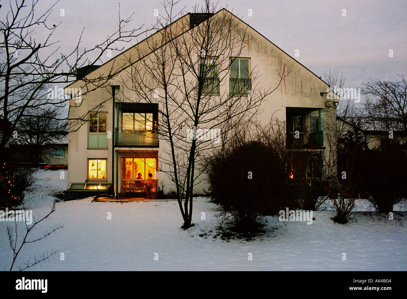 House with illuminated window in winter Stock Photo - Alamy
