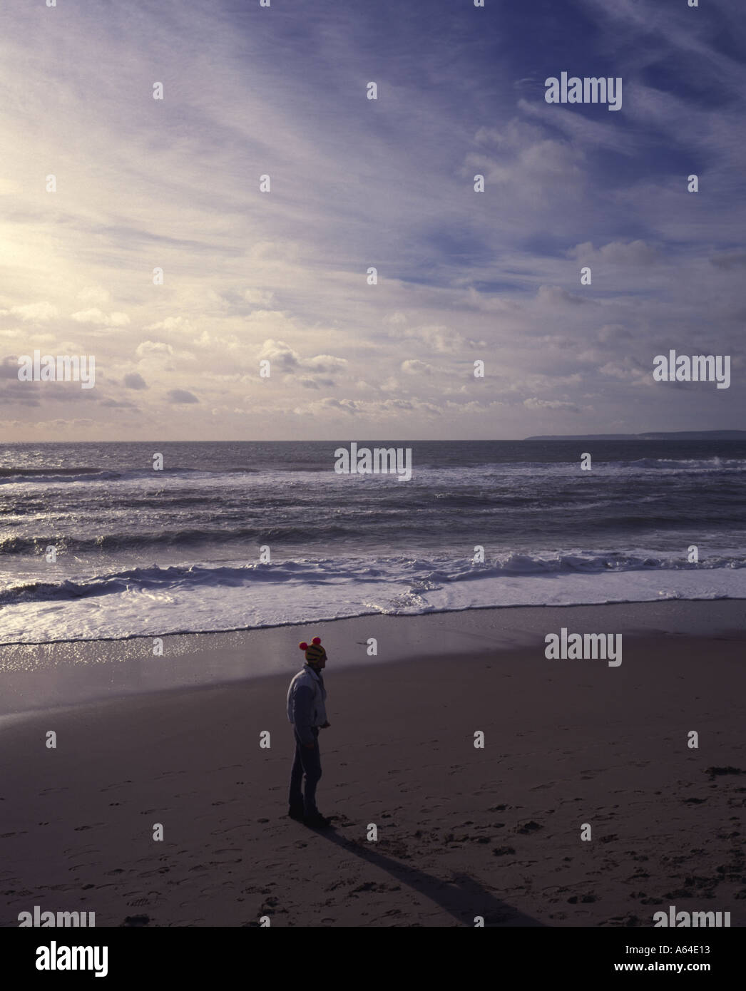 Man with silly hat with mouse ears on wind swept beach in winter Stock ...