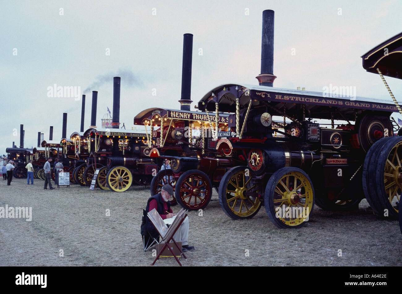 Artist painting a gathering of agricultural and fun fair steam engines ...