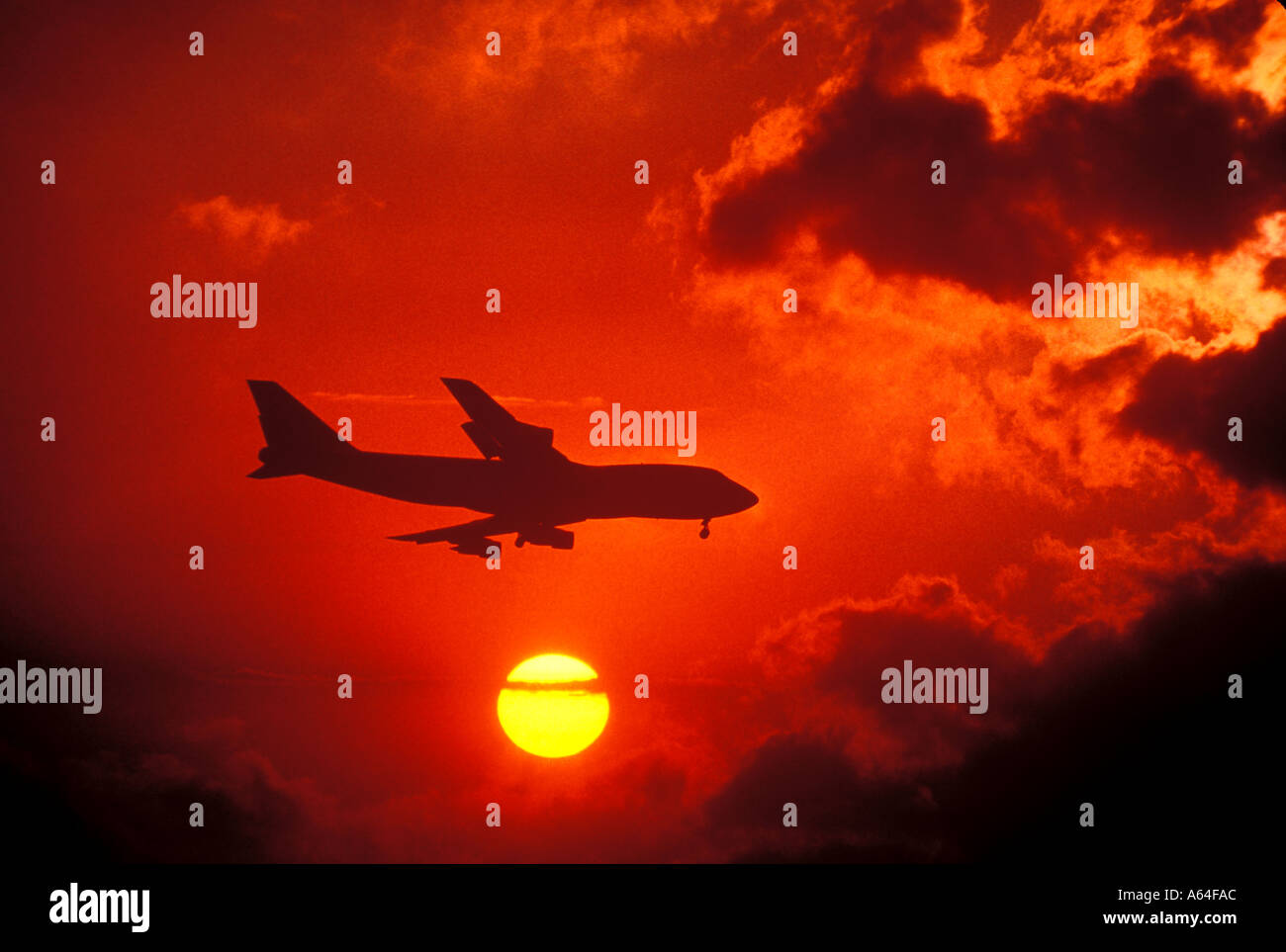 Jetliner in flight at sunset with clouds Stock Photo - Alamy
