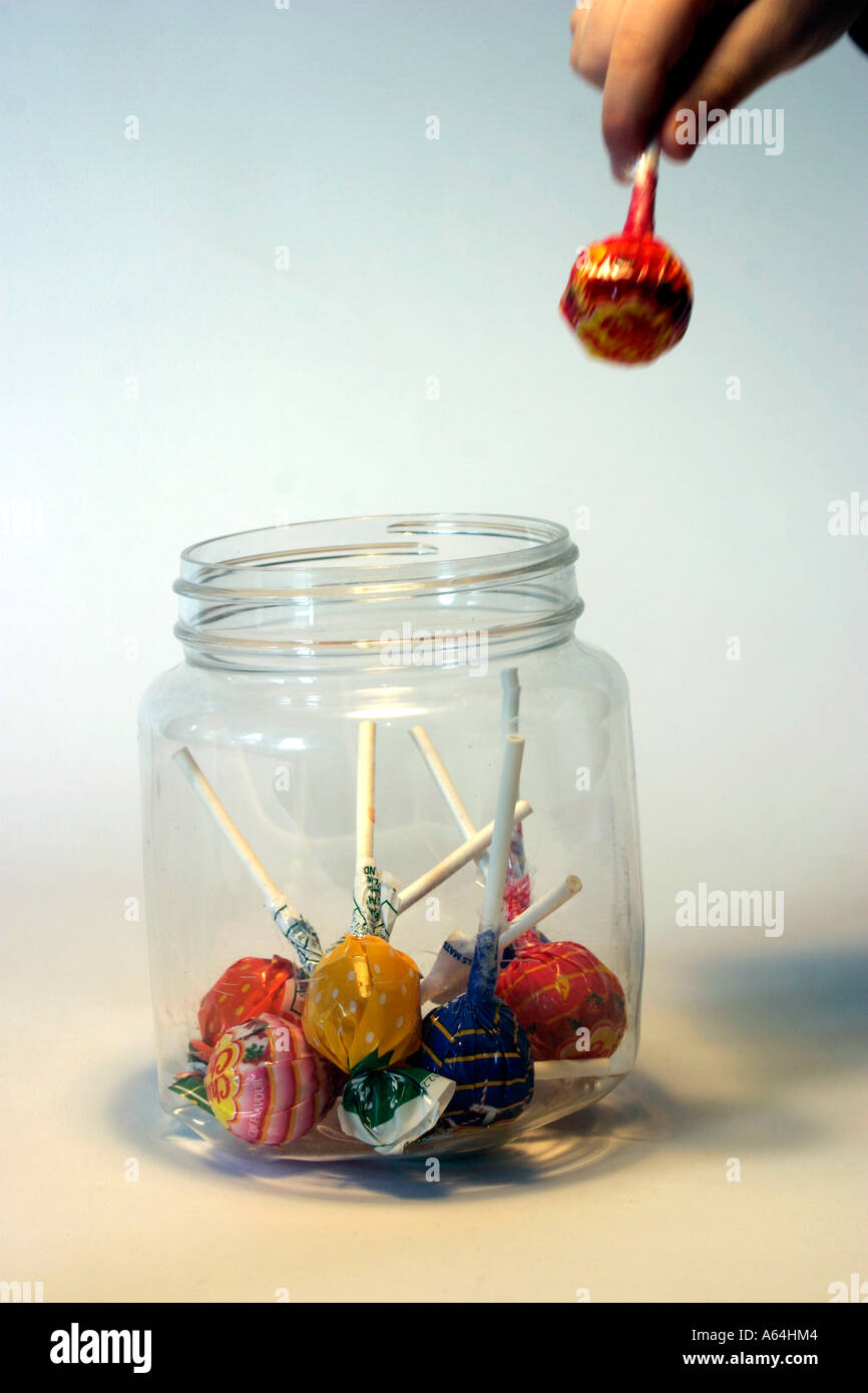 A hand taking a lollipop sweet from a selection of Lollipop sweets in a ...