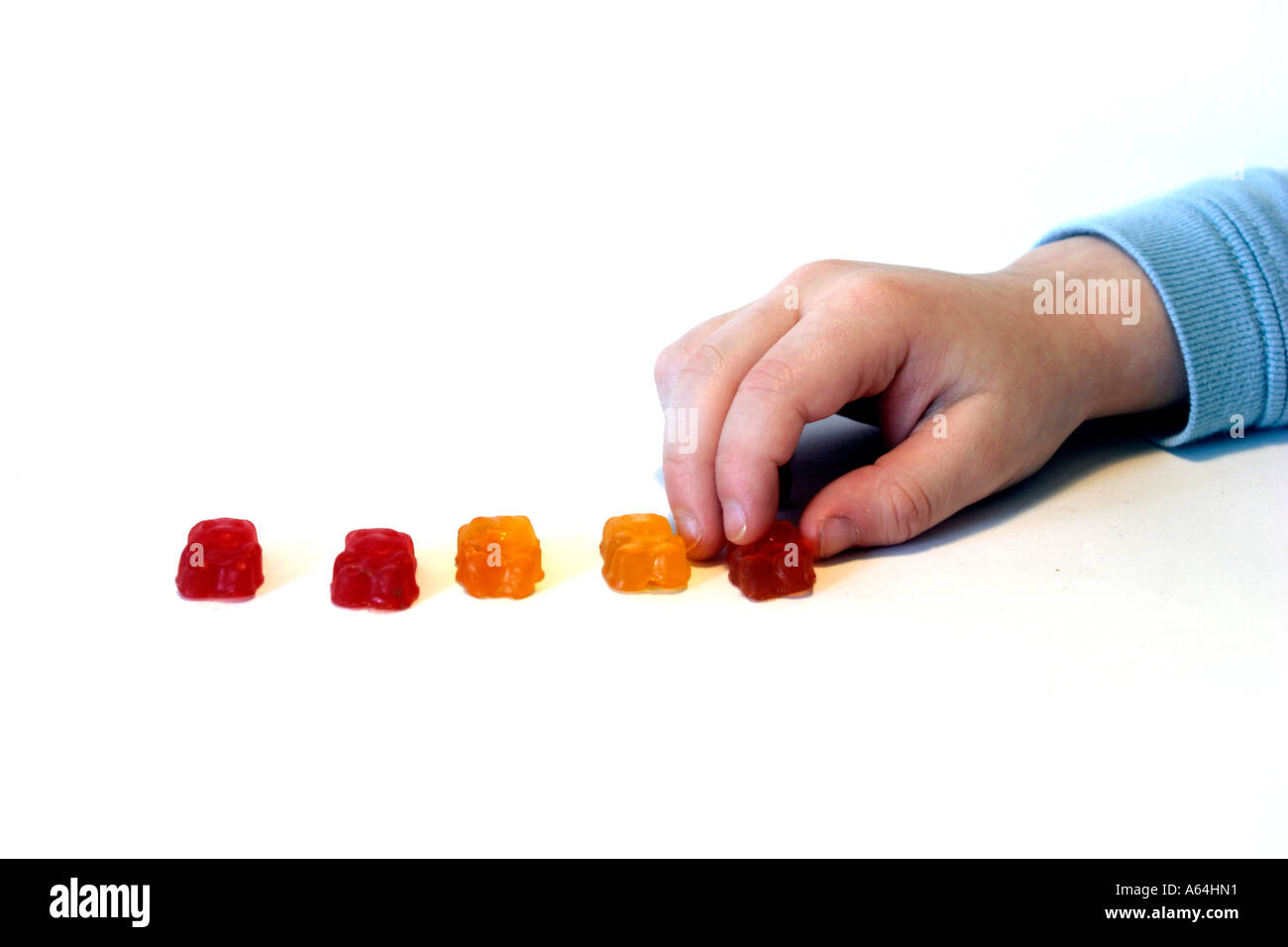A hand taking sweets on a white background Stock Photo - Alamy