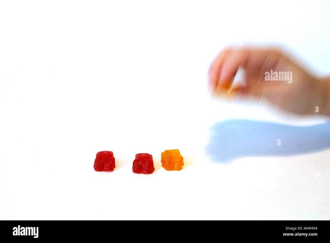A hand taking sweets on a white background Stock Photo - Alamy