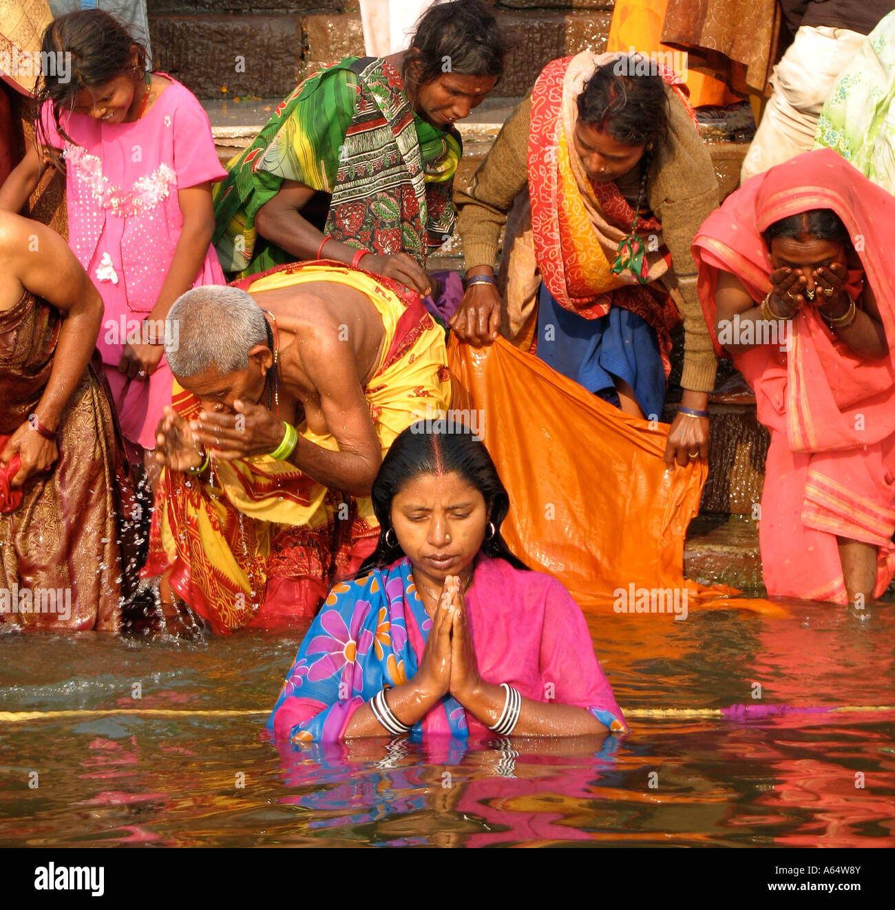People bathing and praying at the river Ganges on the ghats in Varanasi ...