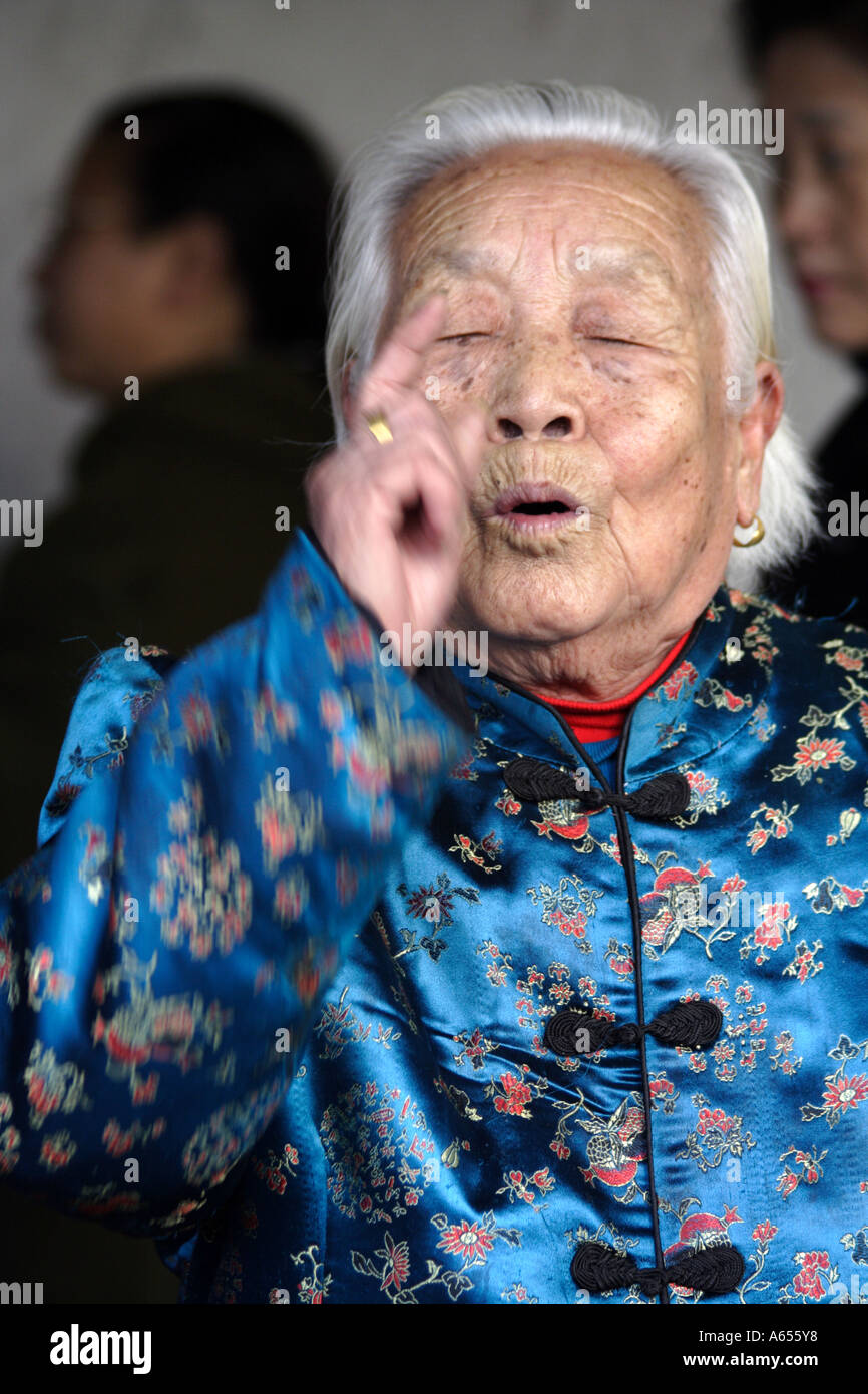 Old woman singing a traditional song to an audience in Temple of Heaven ...
