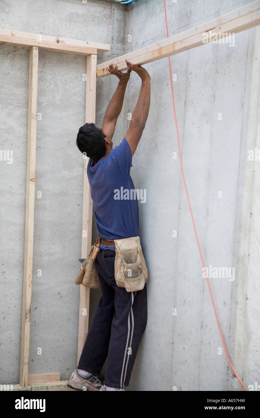 Immigrant Construction Worker Framing the House Stock Photo - Alamy