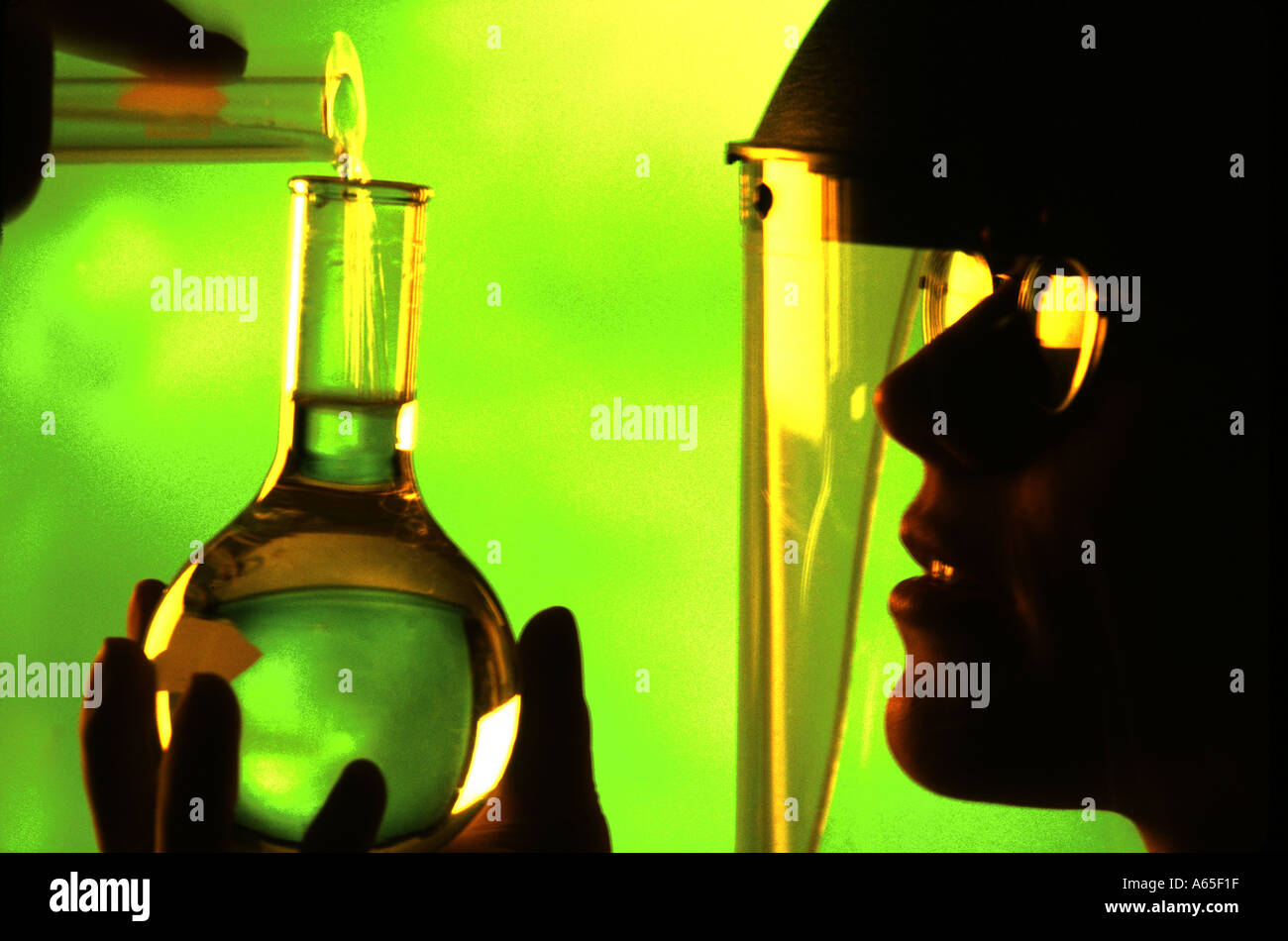 lab technician checking beaker from test tube Stock Photo - Alamy