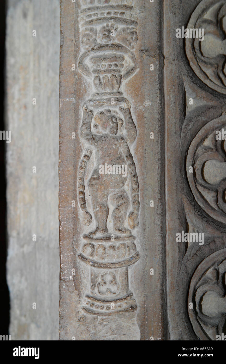 Early medieval stone carving of man standing on plinth. From a panel ...