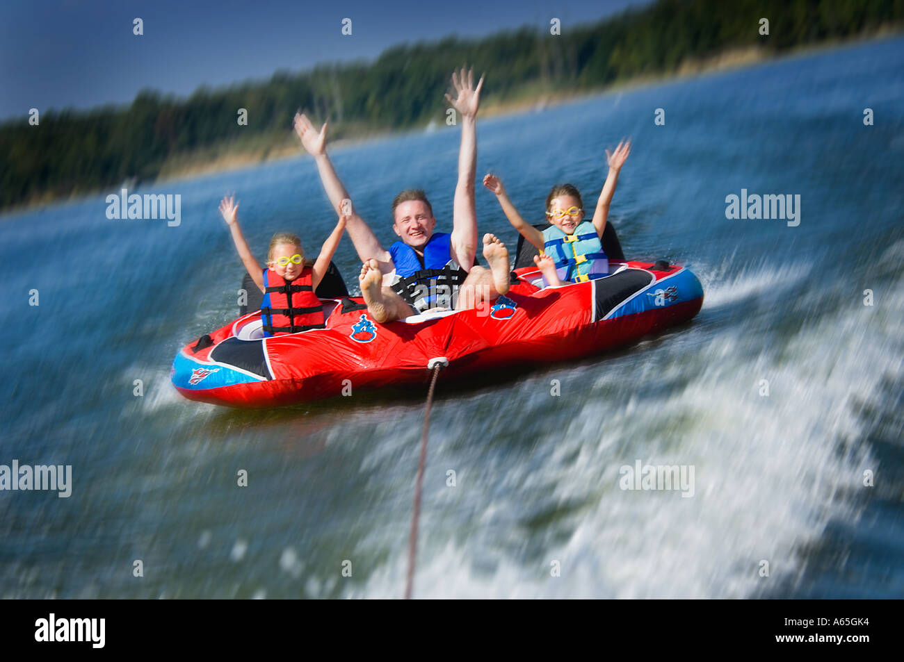 Dad with kids on inner tube Stock Photo - Alamy