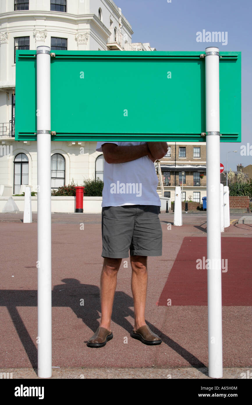 Lost man looking at green notice board for directions in Dover, Kent ...