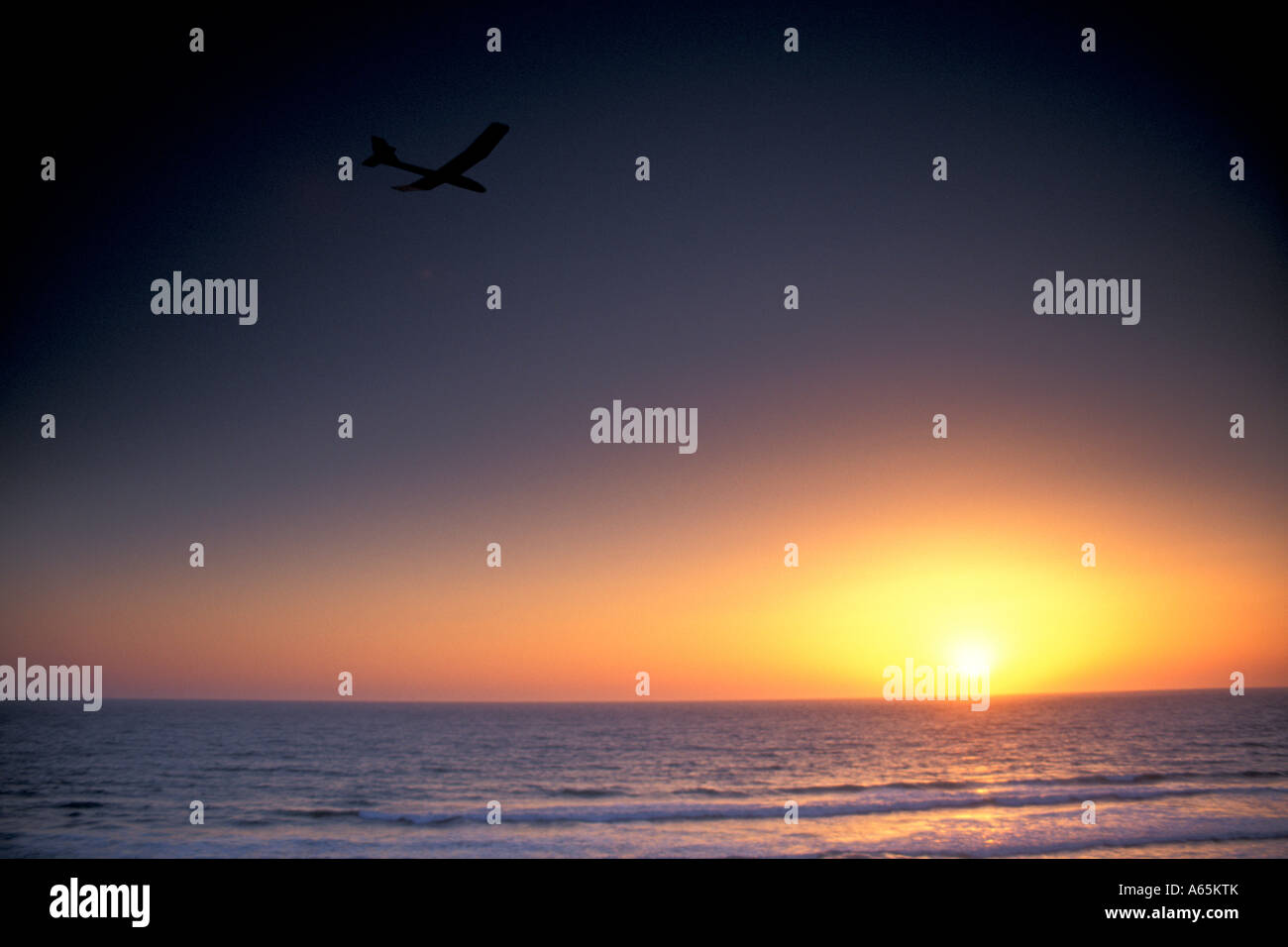 Radio controlled glider at sunset flying over the Pacific Ocean ...