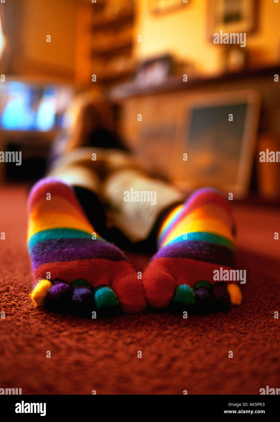 Young girl watching the TV in rainbow coloured toe socks Stock Photo ...