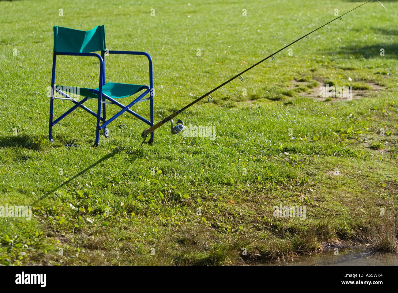 Anglers chair and rod by lake Stock Photo - Alamy