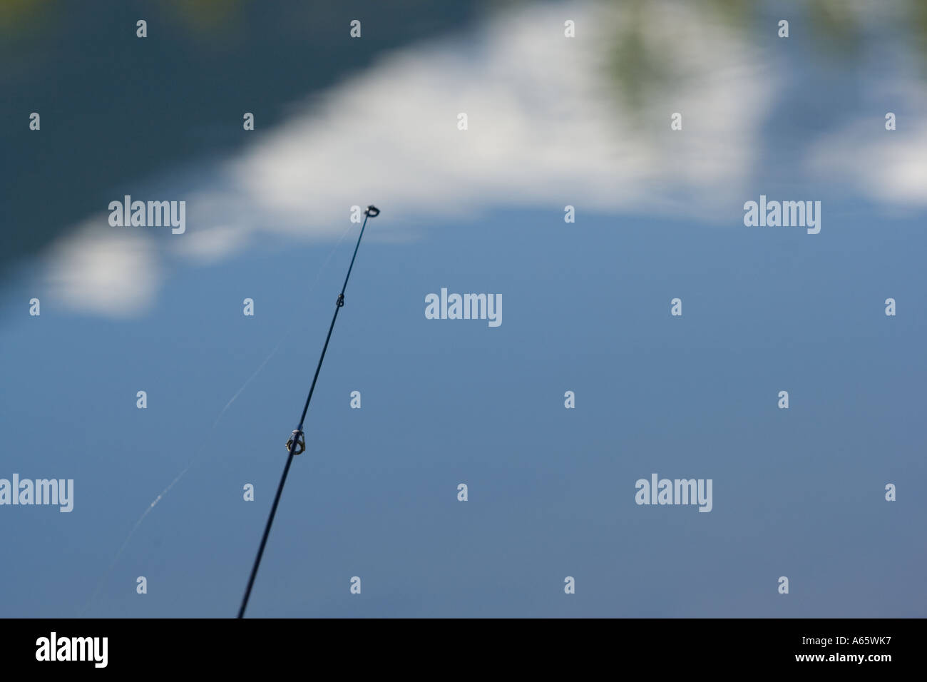 Fishing rod and line, angling in fresh water lake reflecting the Alps ...