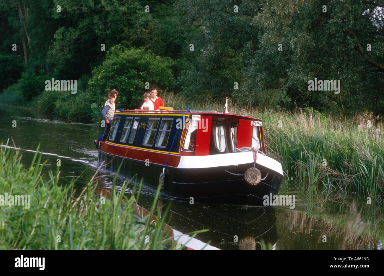 A family aboard a modern steel motor narrowboat on the Kennet and Avon ...