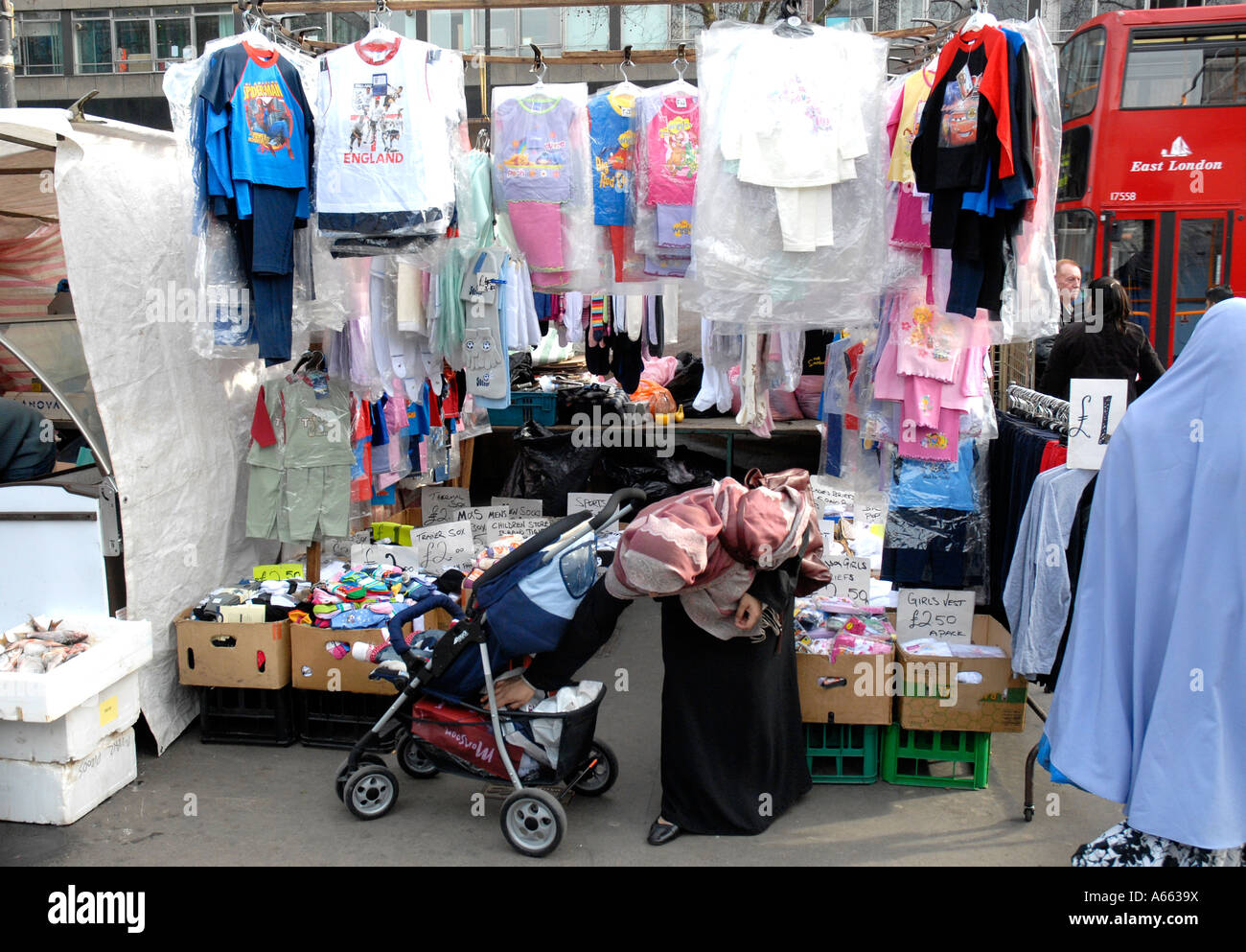 Muslim woman with a pushchair in Whitechapel Road street market ...