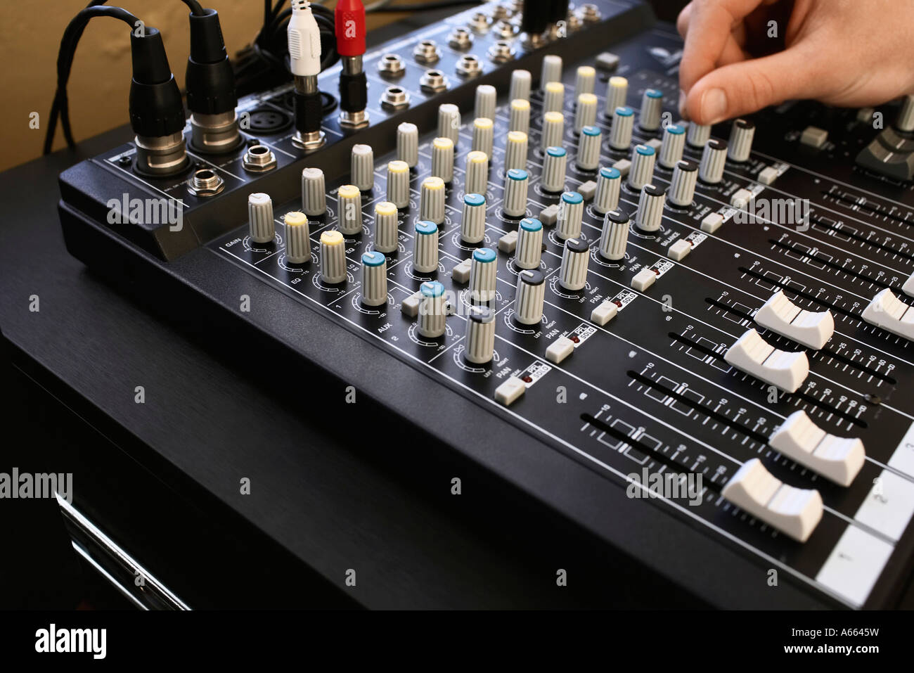 Man adjusting knob on mixing console, close-up Stock Photo - Alamy