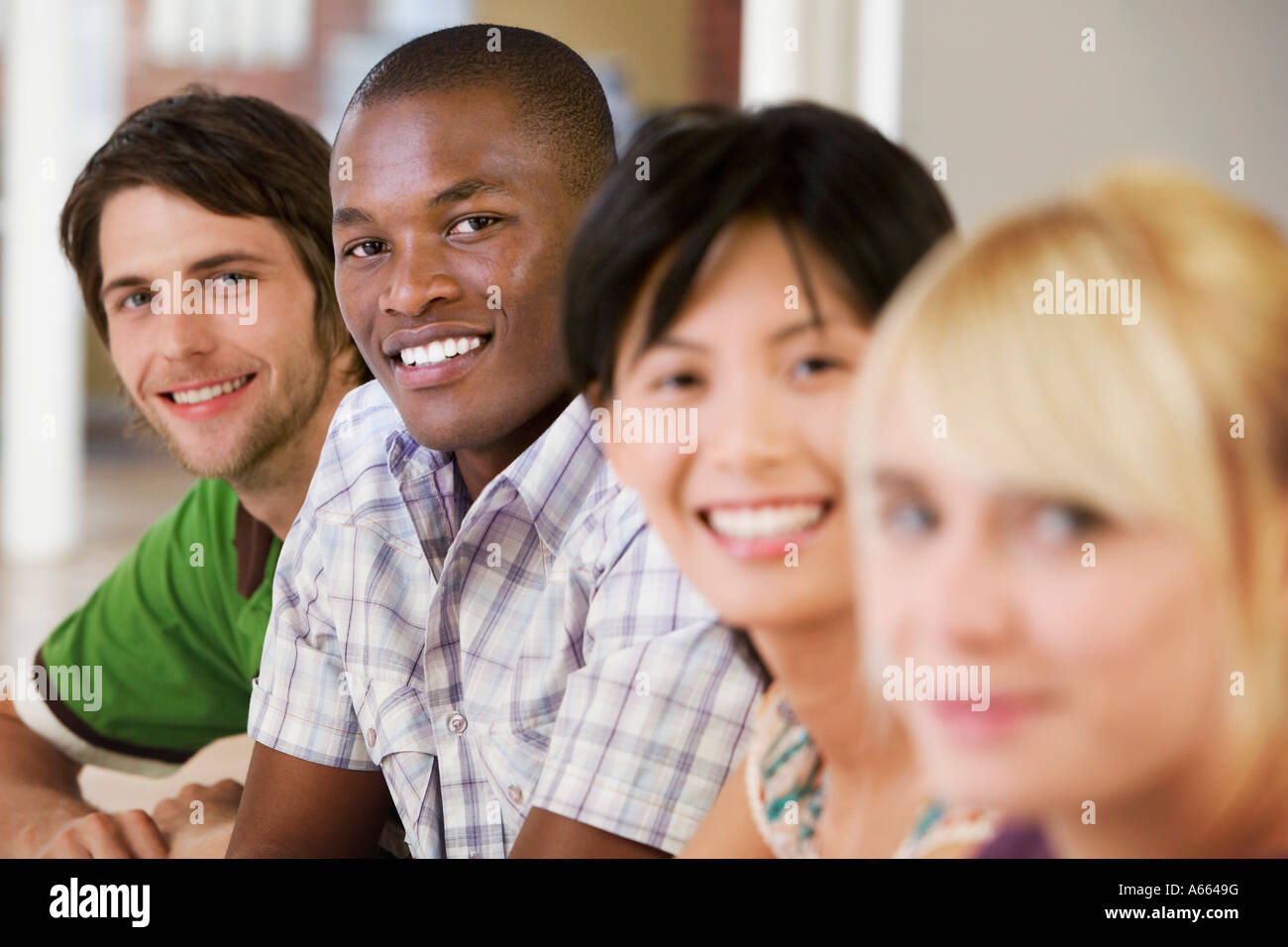 Four People in a Row, smiling Stock Photo - Alamy