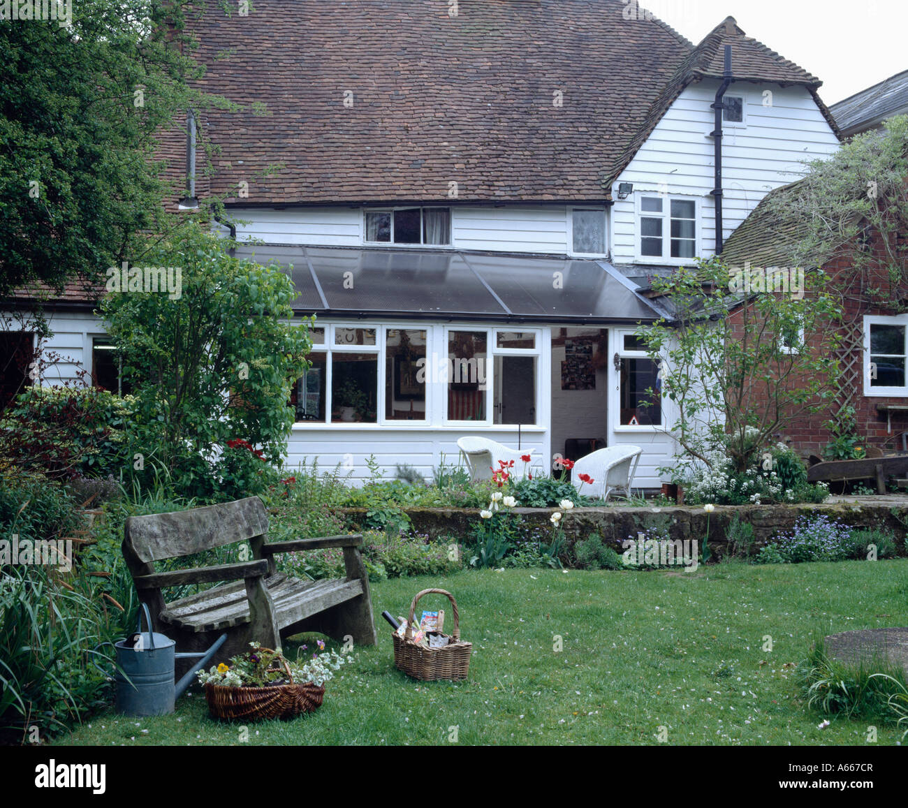 Wooden bench on lawn outside white country house Stock Photo - Alamy