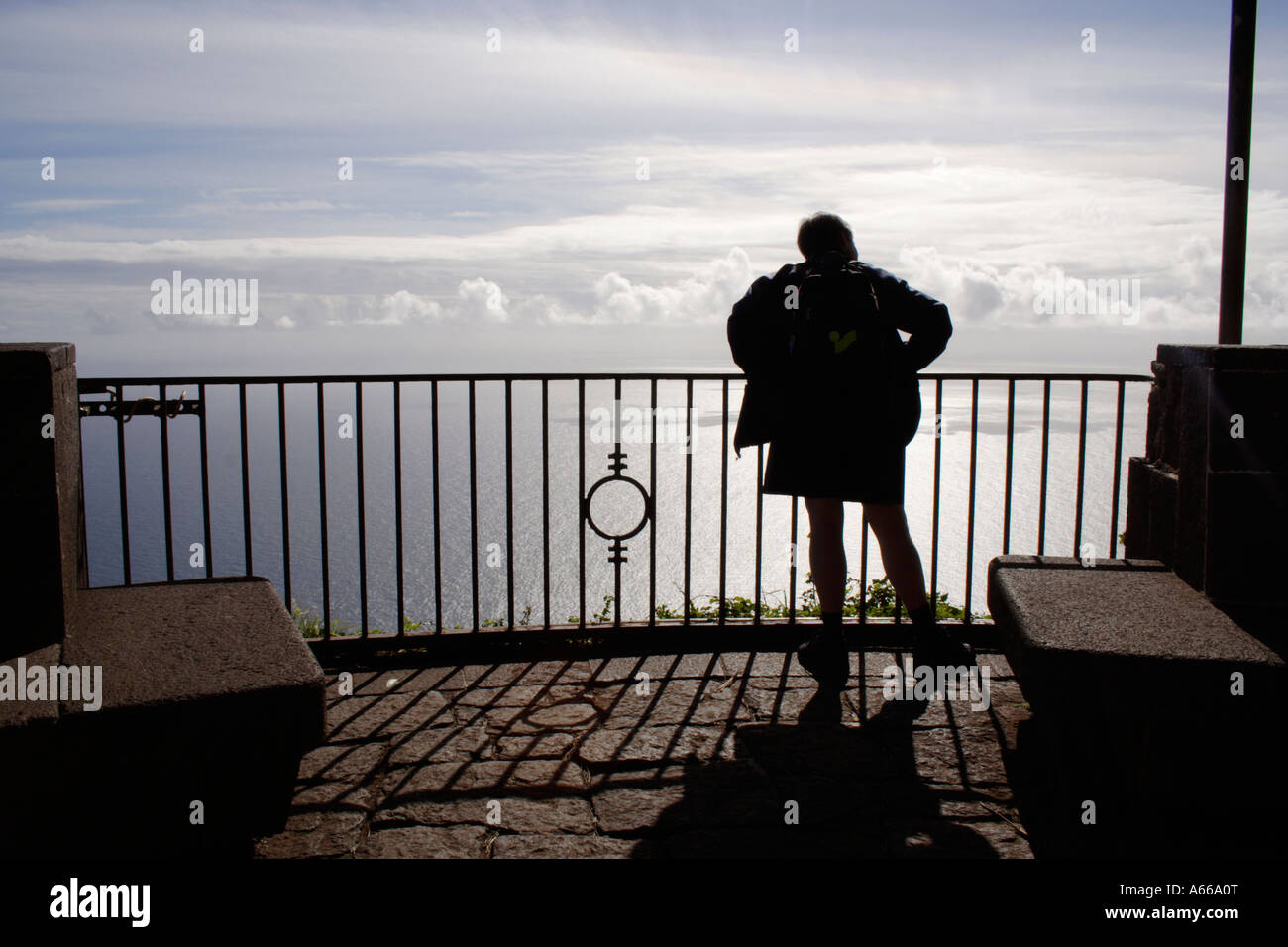 silhouette of a solitary figure looking out from a vantage point above ...