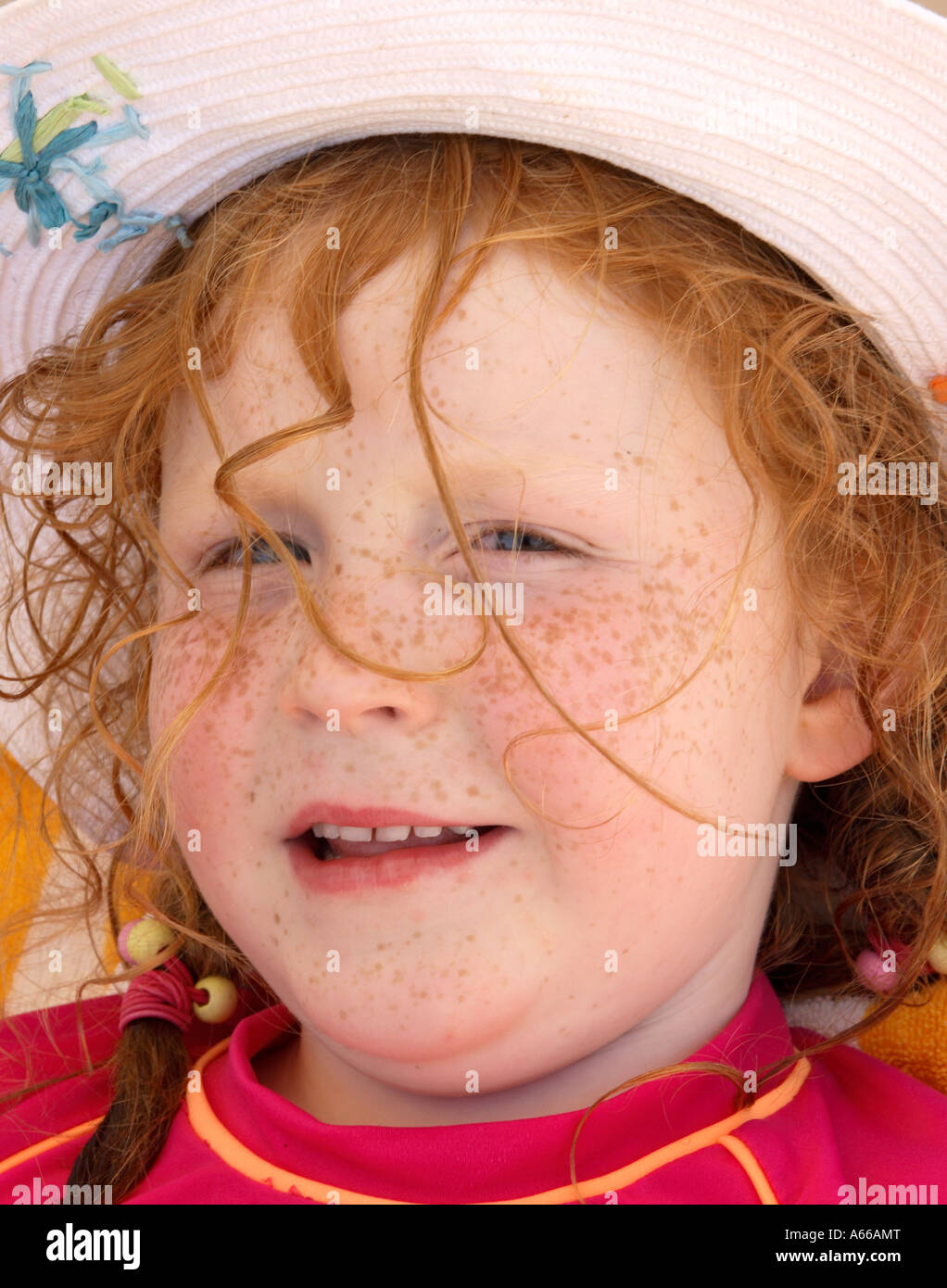 a little girls face with red hair and freckles wearing a sun hat Stock ...