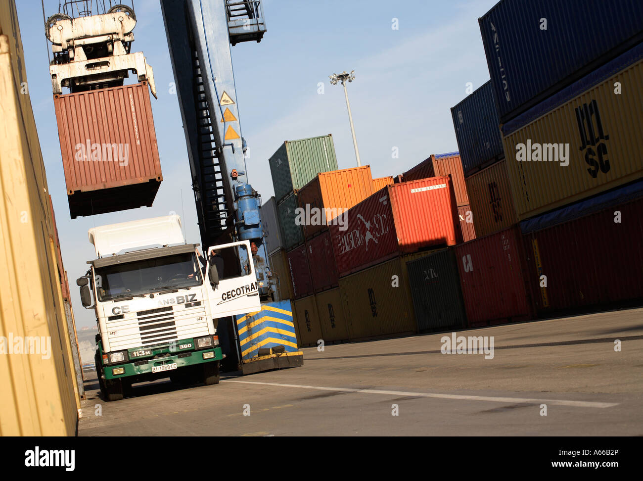 a lorry being loaded with a shipping container at a port Stock Photo ...