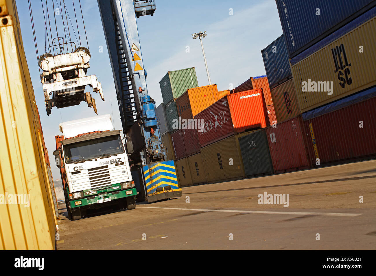 a lorry being loaded in a container port surrounded by containers Stock ...